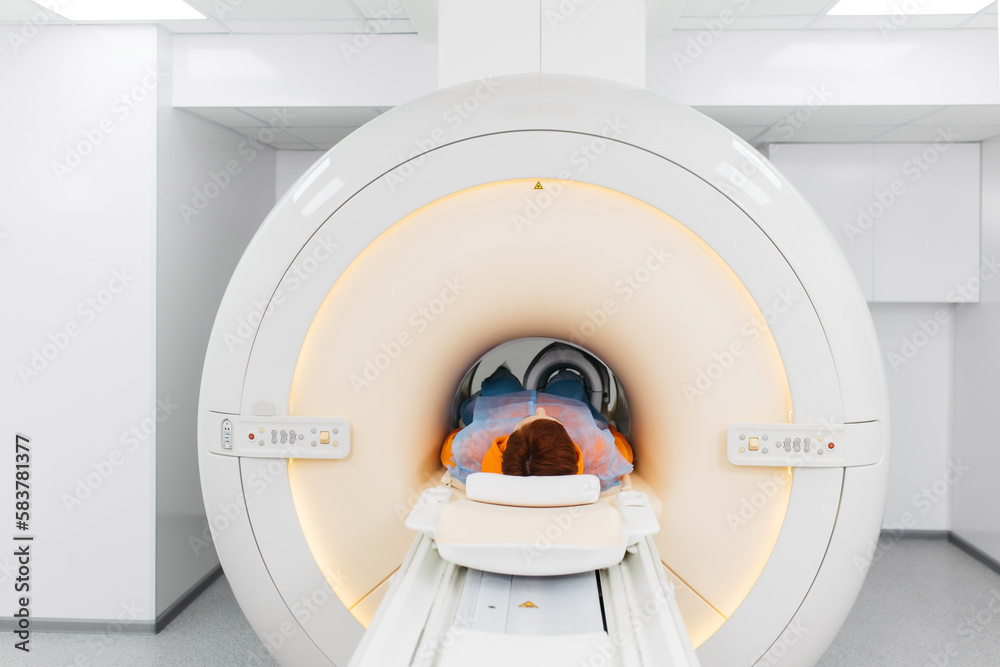 Young patient on automatic table moving outside of closed-type mri ...