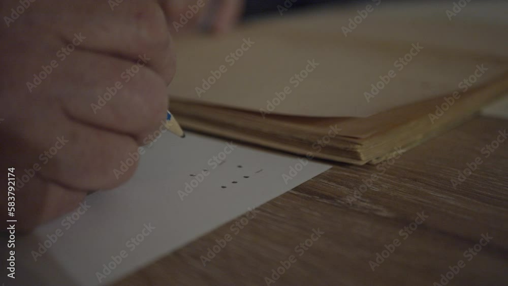 Man writing noting morse code on a sheet of paper from an old book 4K ...