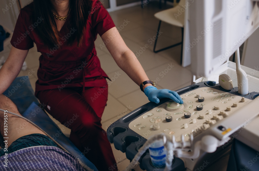 Medical specialist performing doppler ultrasound of the lower limb ...