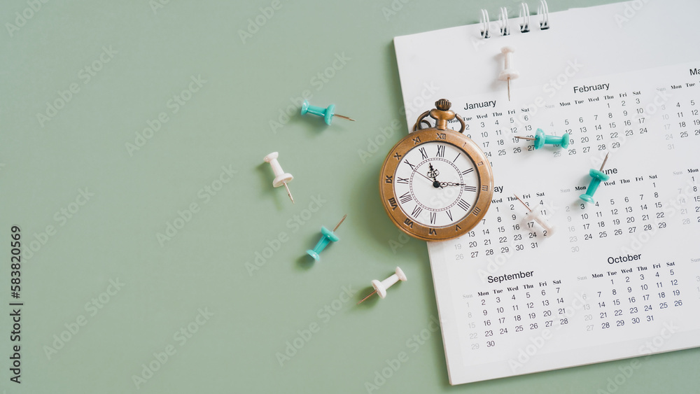 Foto de vintage clock and grunge white yearly calendar, green thumbtack ...