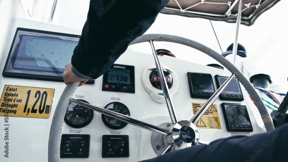 Skipper steers the catamaran. Close-up of the skipper's hands on the ...