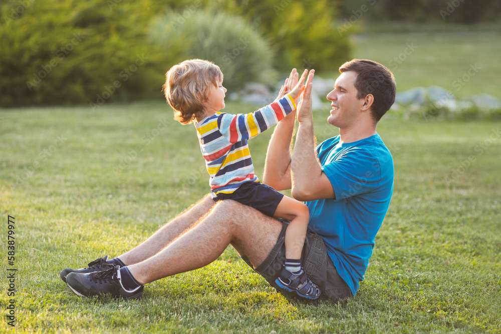 Young dad playing together with his little son patty-cake game on the ...