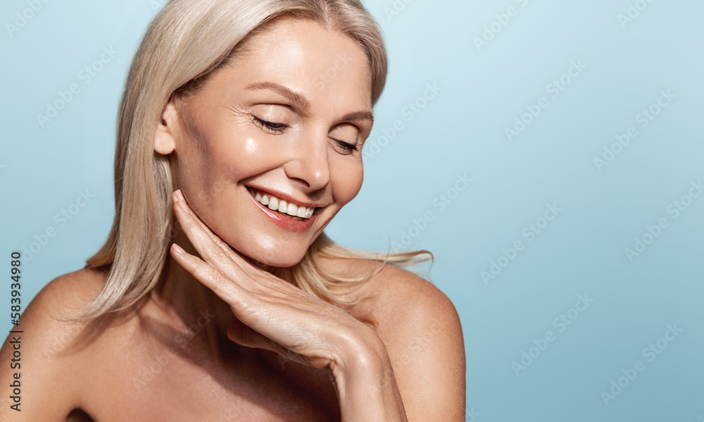 Elegant middle aged woman, head and shoulders with glowing skin ...