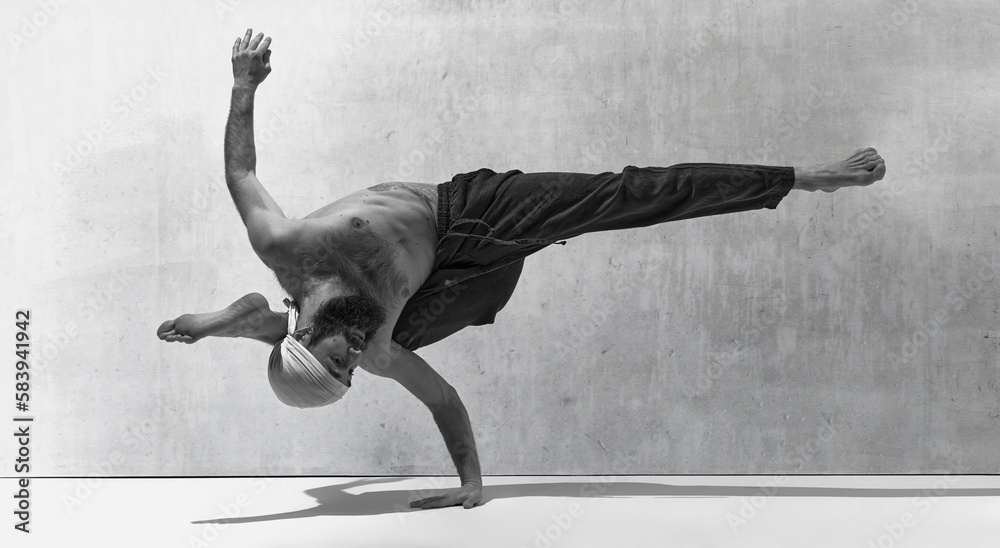 Black and white image, monochrome. Standing at one hand. Bearded strong ...
