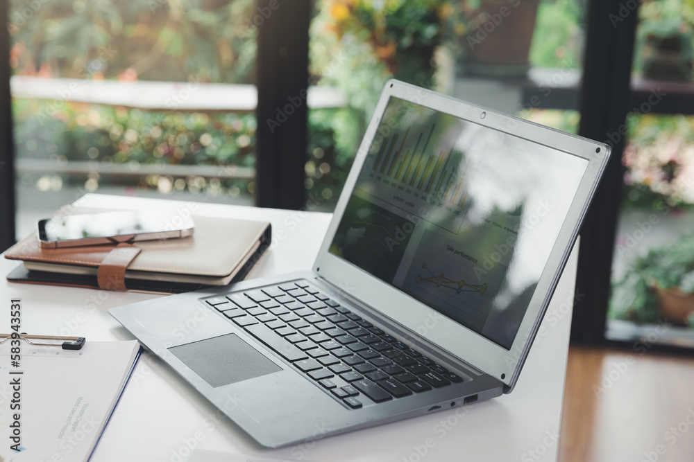 Laptop with graph report on screen on office work desk front view. Home ...