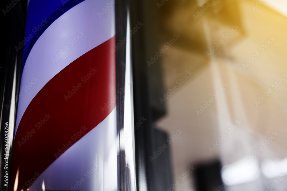 Barber pole spinning at night. International barbershop pole sign. A ...