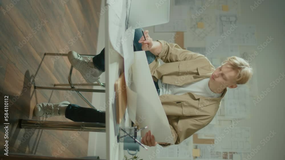 Vertical Video, Vertical View.Focused Engineer Manager with Drawings in ...