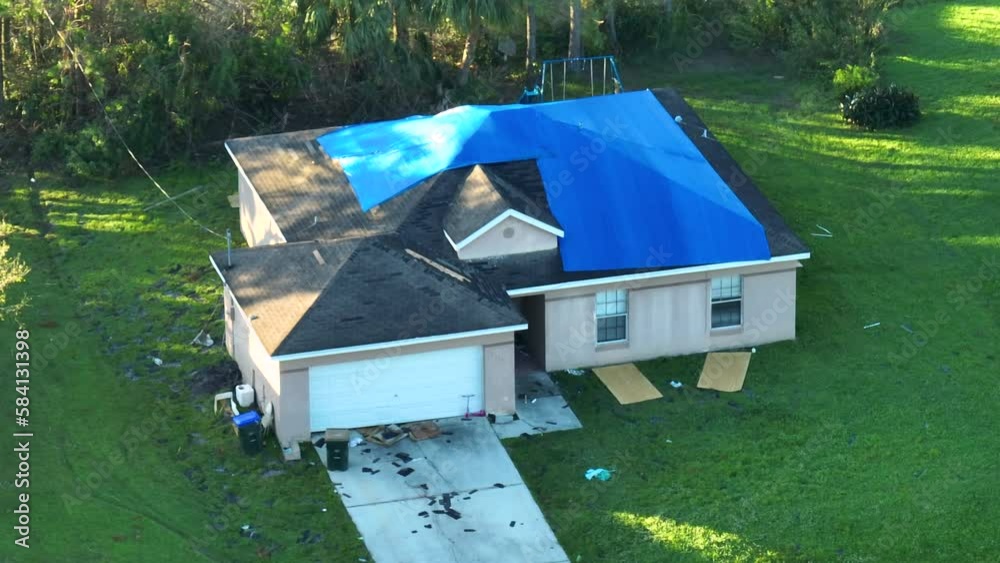 Top view of leaking house roof covered with protective tarp sheets ...