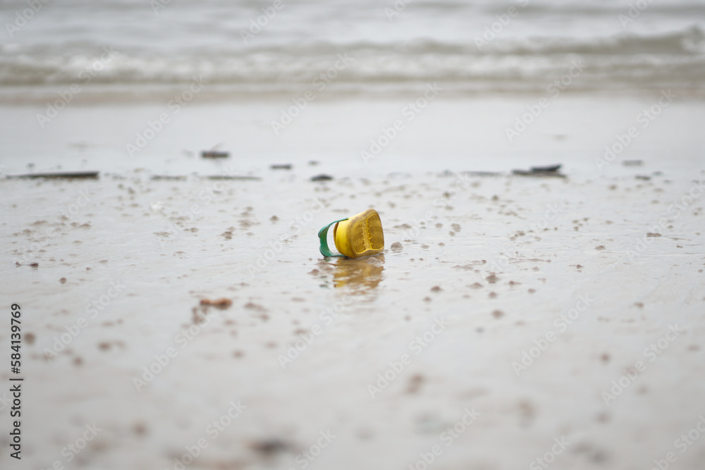 child drowned on the beach. A photo of a yellow sandal on the beach ...