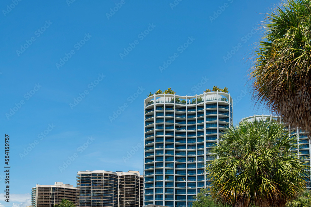 Tall glass residential buildings with trees on roof decks against the ...