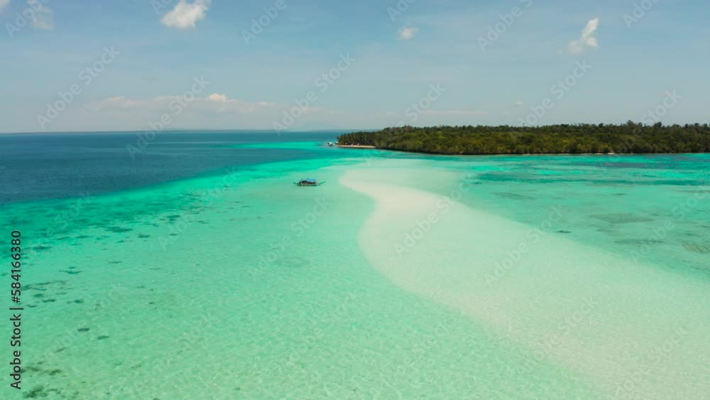 Sandy beach with tourists among turquoise waters and coral reefs ...