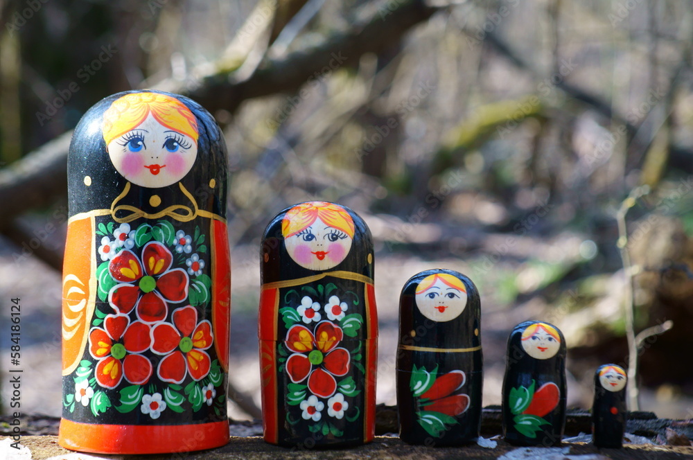 Matryoshka dolls decorated with patterns stand in a row. A cultural ...