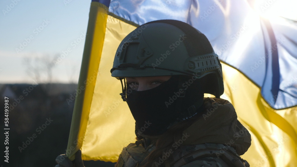 Female military of ukrainian army looks into camera against waving blue ...