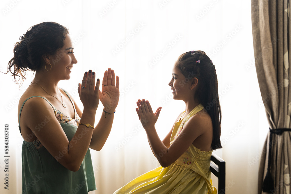 Mother and daughter engaging in a playful clapping game, enjoying a ...