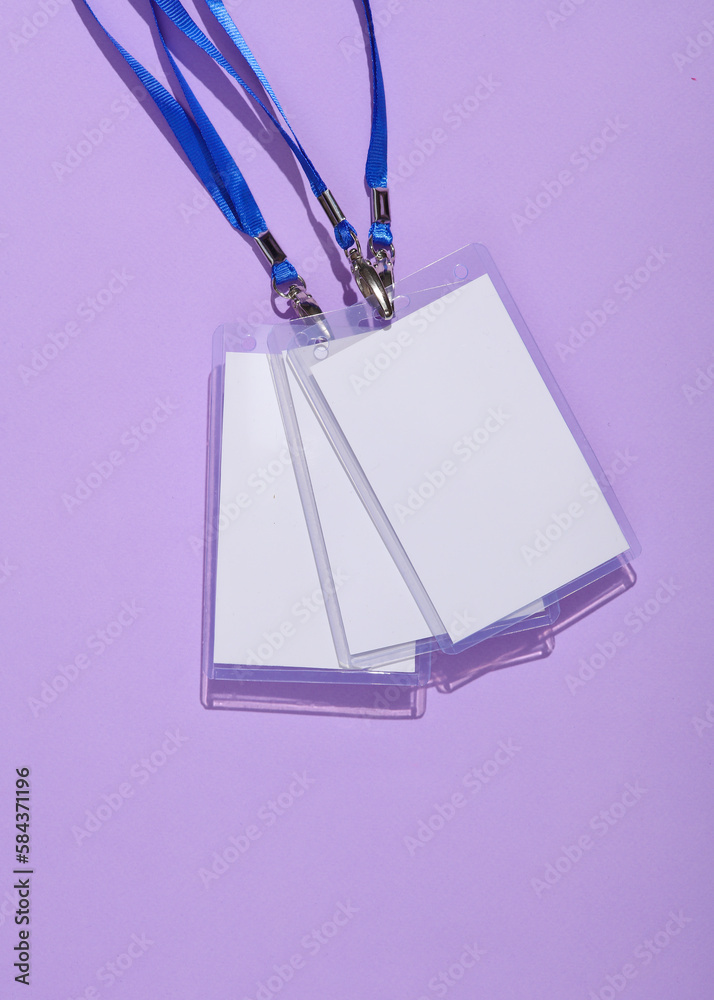 Empty white ID card badges mockup on purple background. Staff identity ...