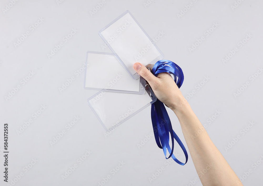 Hand holding Identification white blank id cards on gray background ...