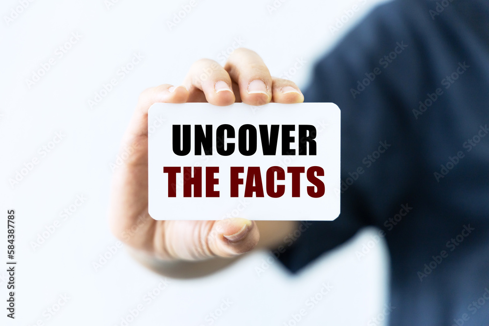 Uncover the facts text on blank business card being held by a woman's ...
