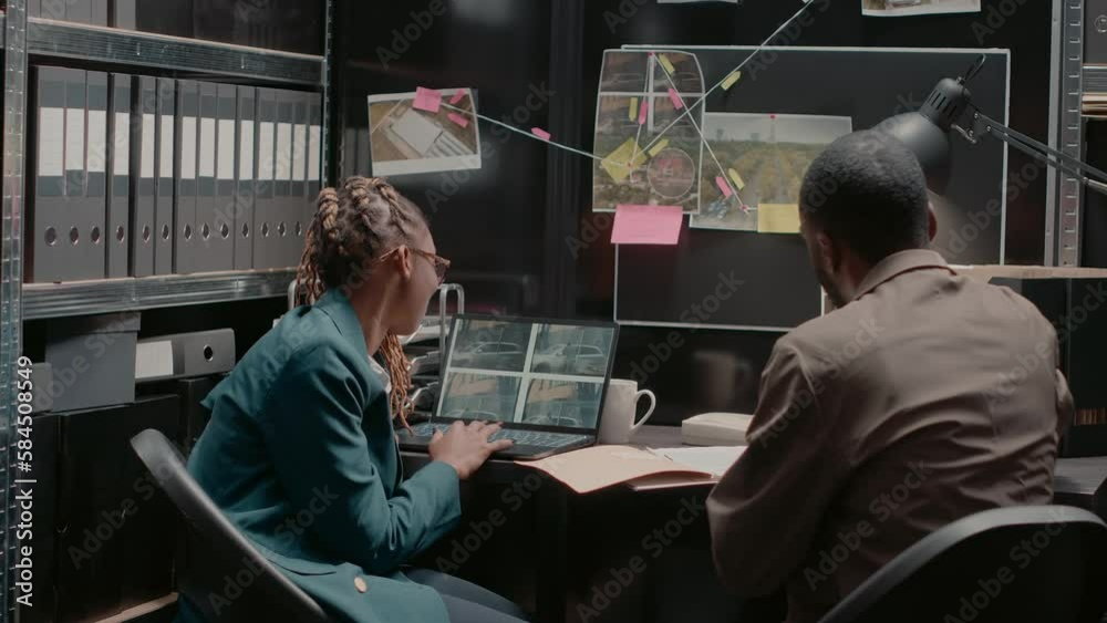Team of detectives analyzing surveillance records and reading case file ...