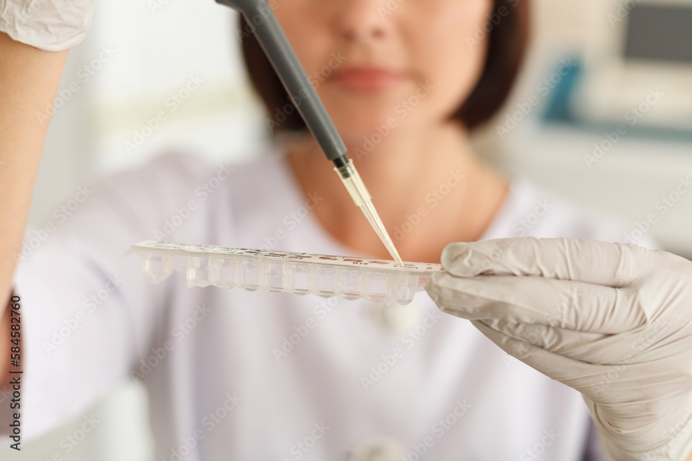 Female biotechnology medical scientist using working with micro pipette ...