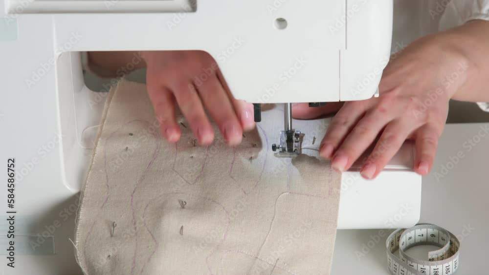Animation video shows cropped woman sewing on template textile patterns ...