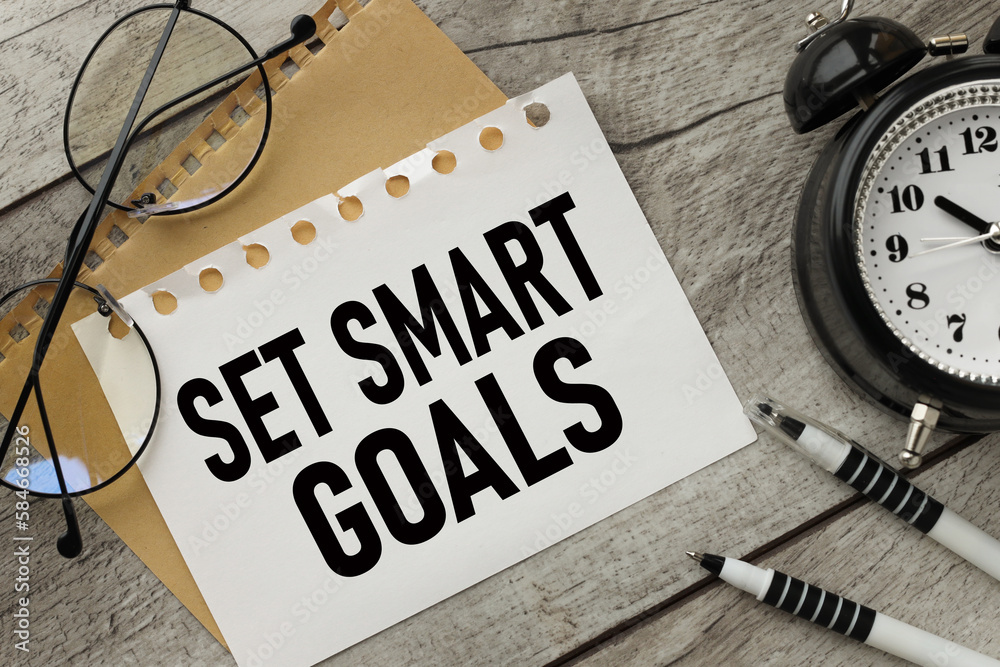 Set smart goals text on torn paper close-up. table and glasses ...