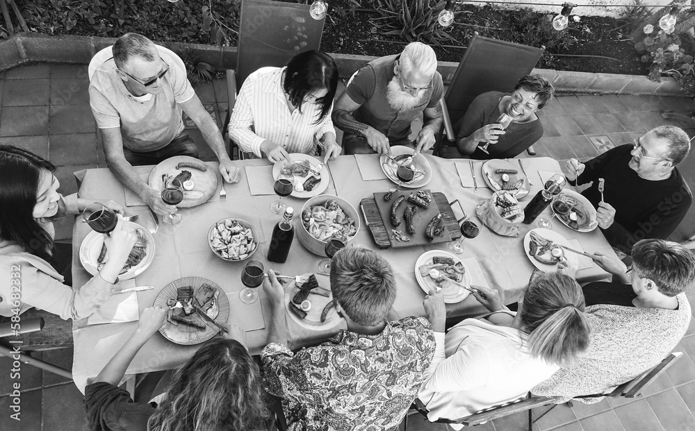 Multiracial family people eating at barbecue dinner at patio terrace ...