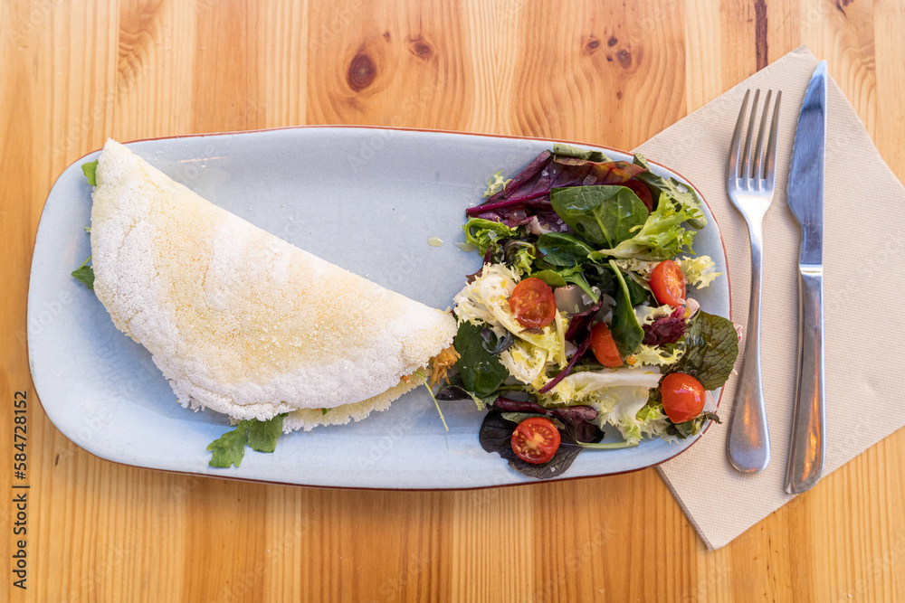 Up view of brazilian tapioca salted crepe with side salad. Typical ...