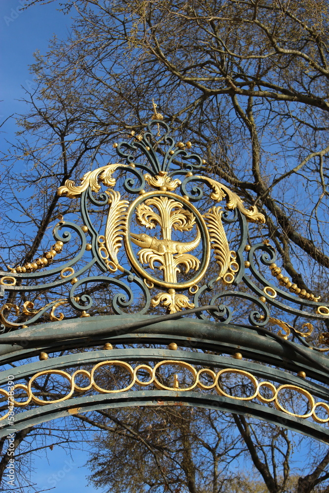 Ornate golden gate topping at the entrance to the Jardins de la ...