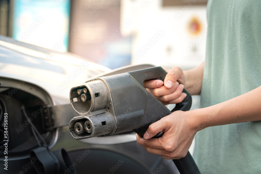 CCS2 DC charger socket head for charging the EV car is holded by human ...