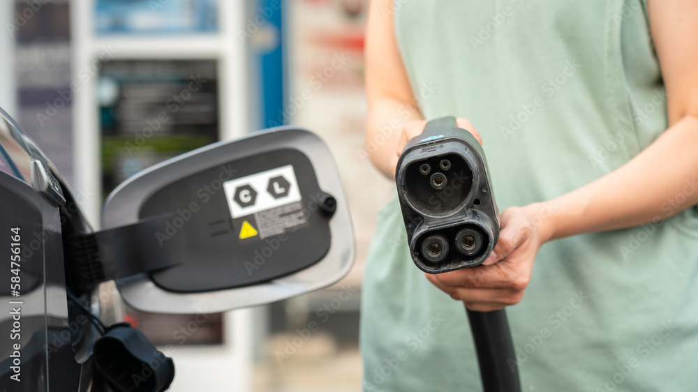 CCS2 DC charger socket head for charging the EV car is holded by human ...