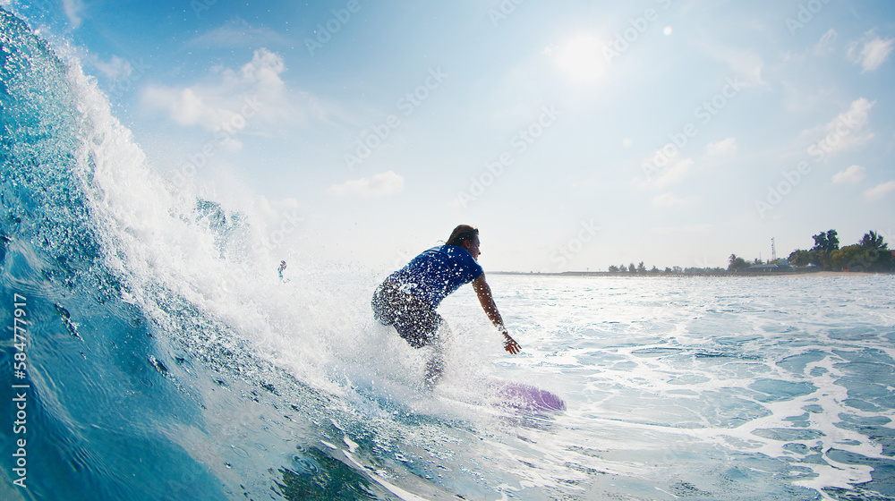 Girl surfer rides the wave. Woman surfs the ocean wave in the Maldives ...