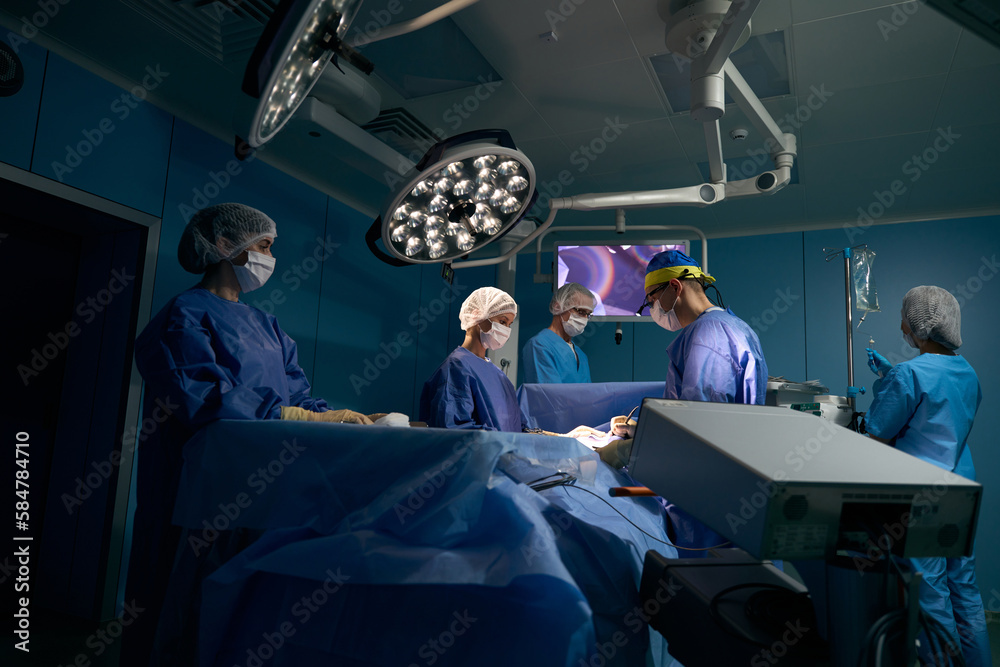 Teamwork of a surgeon, anesthetist and assistants in operating room ...