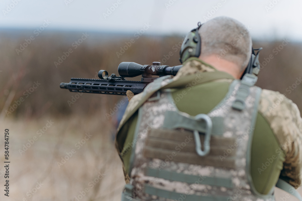 A military soldier of the army is firing a machine gun. Shooting and ...