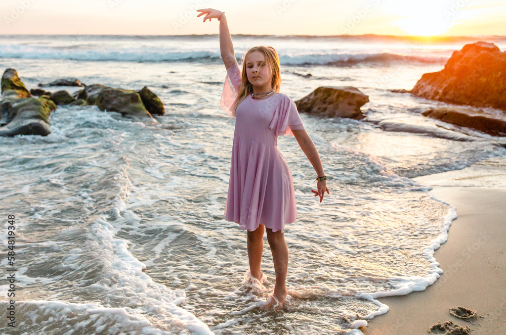 Happy tween girl in pink dress dancing on beach Stock Photo | Adobe Stock