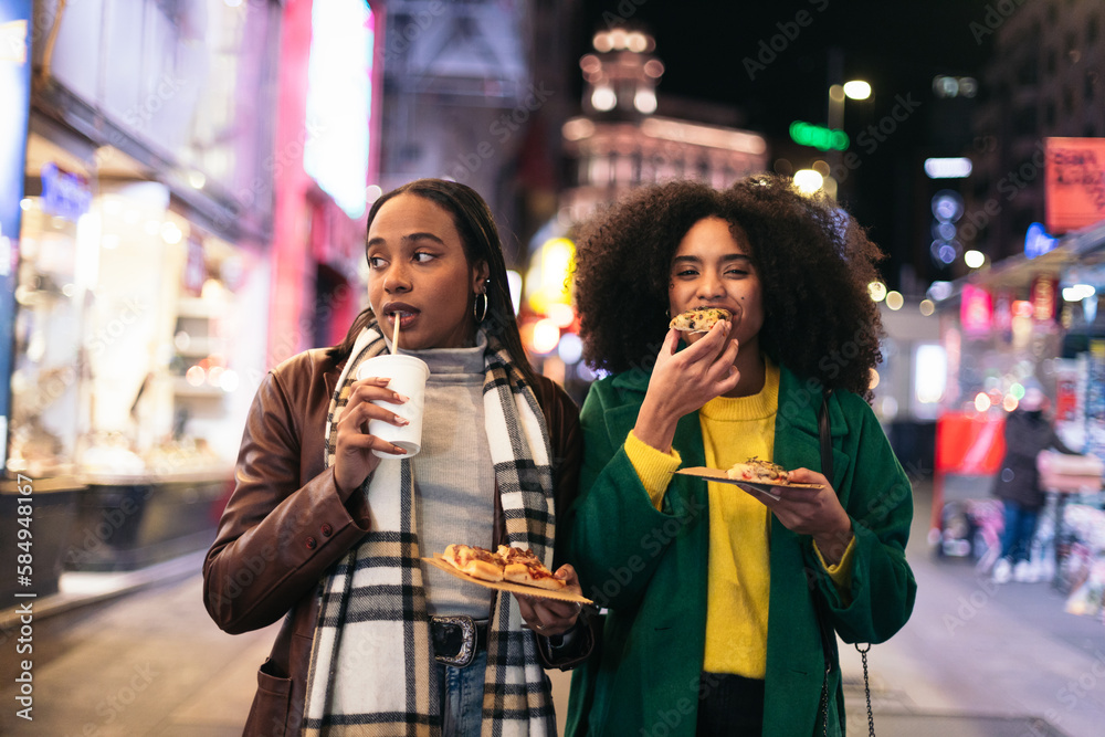 Young black women eating fast food on the street at night Stock Photo ...