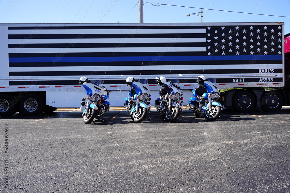 State patrol motorcycle police interceptors sit in front of Semi truck ...