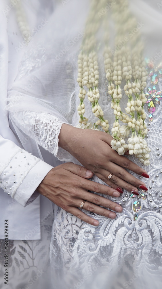 couple gently holding hands in bridal attire. bridal hands with elegant ...