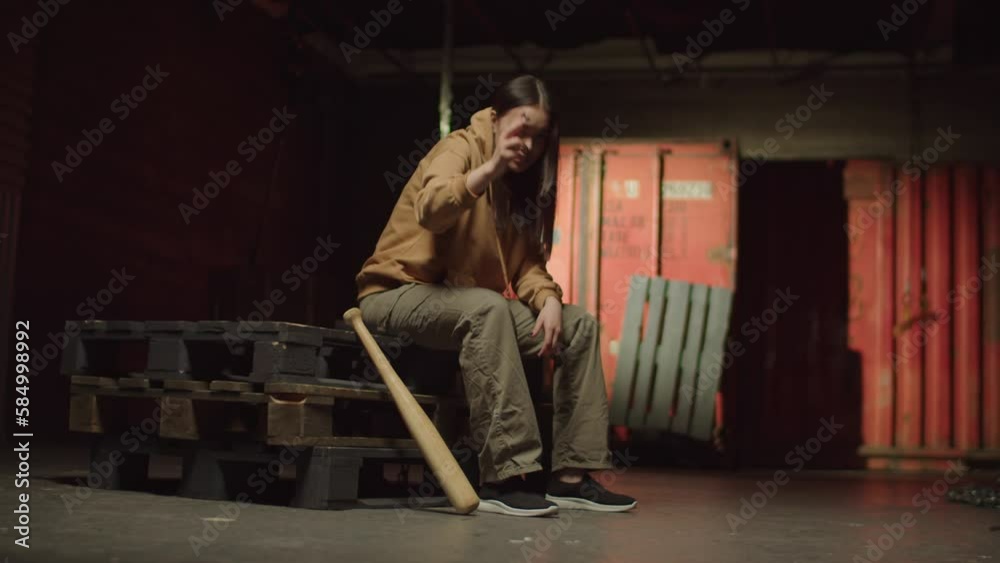 Aggressive tough Asian hooligan woman in street style clothes sitting ...