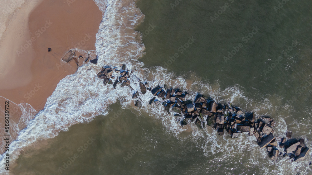 drone photo of the ocean wave with white foam resembling a fish tail ...