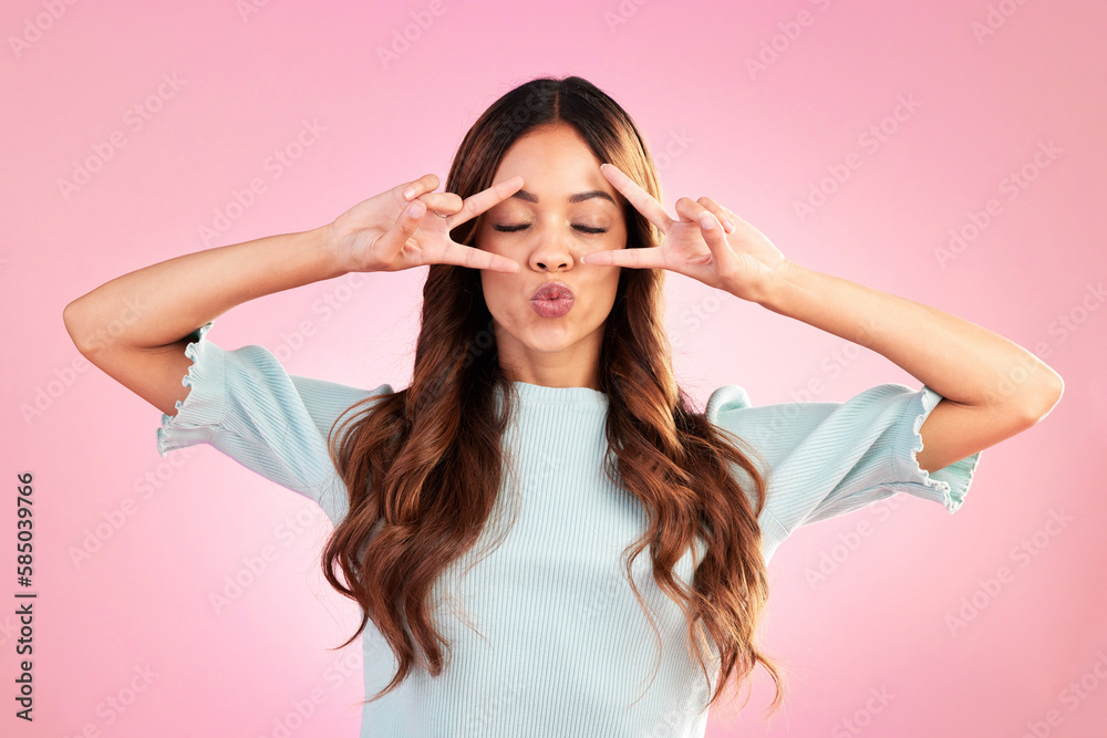 Peace sign, kiss and face of woman in studio for happiness ...