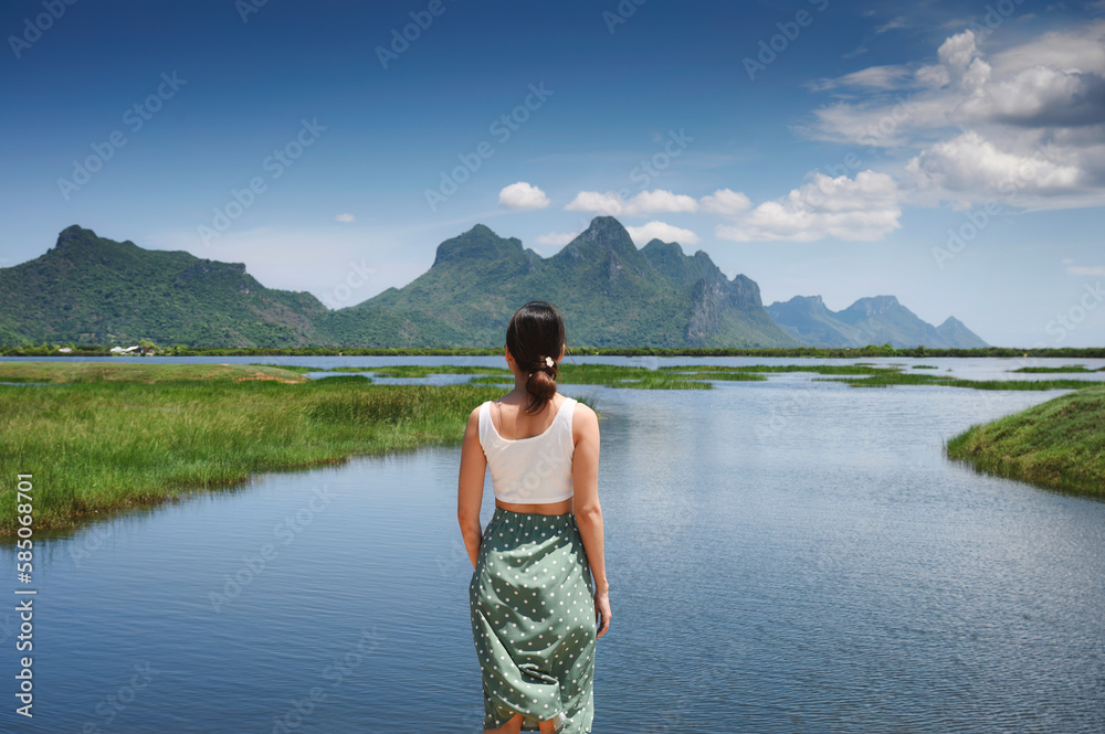 Young asian woman standing with limestone mountain range on wetland at ...