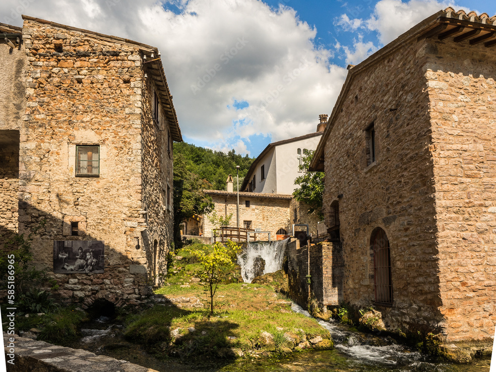 rustic stone houses flank one of the many water channels in the ...