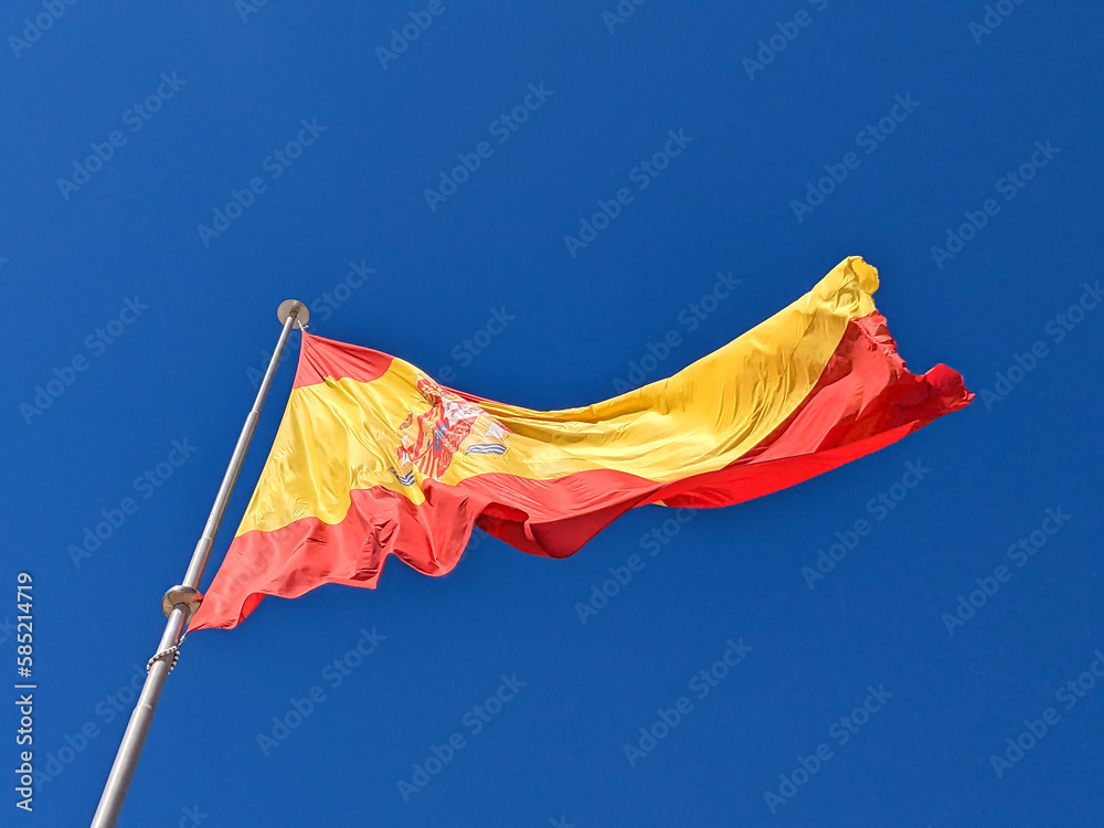 Spanish national flag waving on blue sky background. The flag on ...
