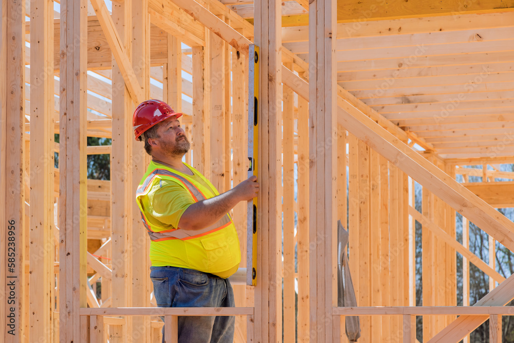Construction engineer checking leveling quality of wooden frame beams ...