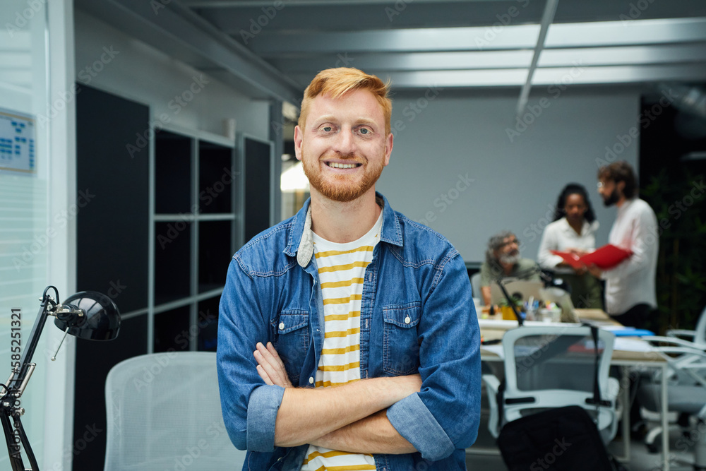 Young red-haired programmer or businessman in a modern office looking ...