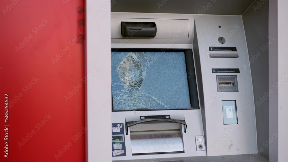Broken glass of red bank ATM on street. touchscreen of banking machine ...