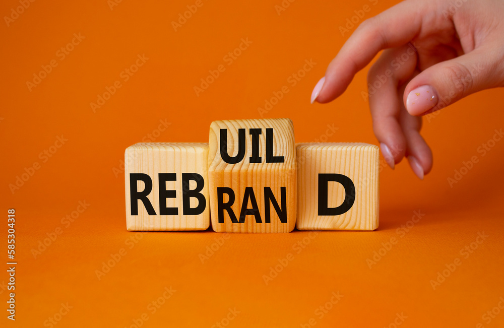 Rebuild and Rebrand symbol. Businessman hand points at turned wooden ...