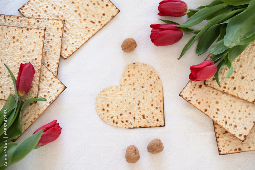 Matzah shape of heart with red tulips and walnut on white background ...