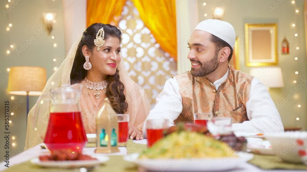 Happy smiling muslim couple by looking camera during ramadan dinner ...