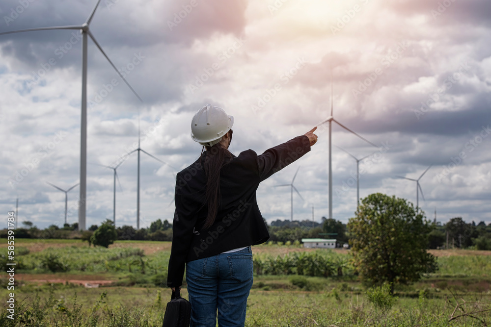 person with a wind turbine. Back view of Asian woman in white helmet ...